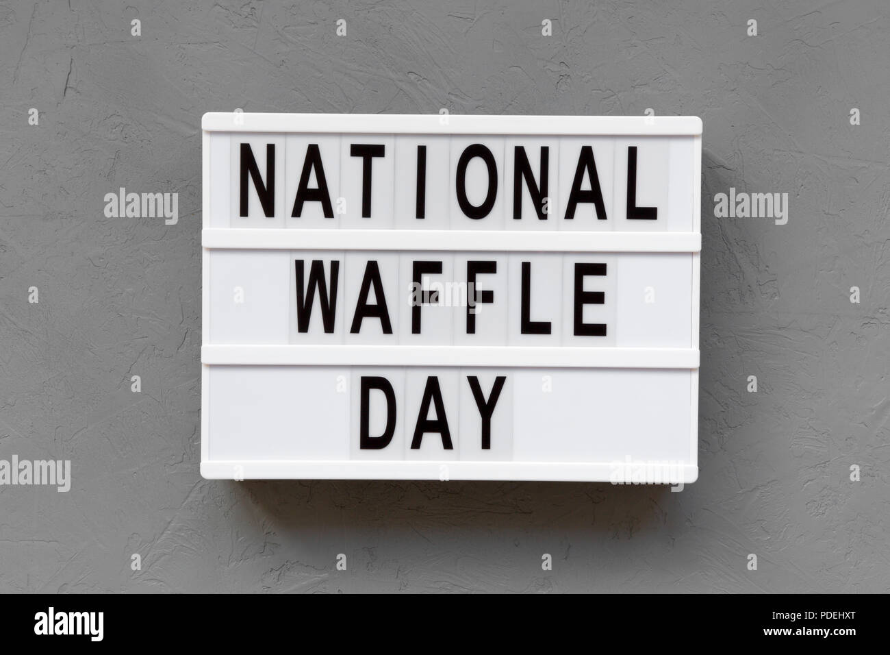 'National Waffle Day' word on lightbox over concrete background, top ...