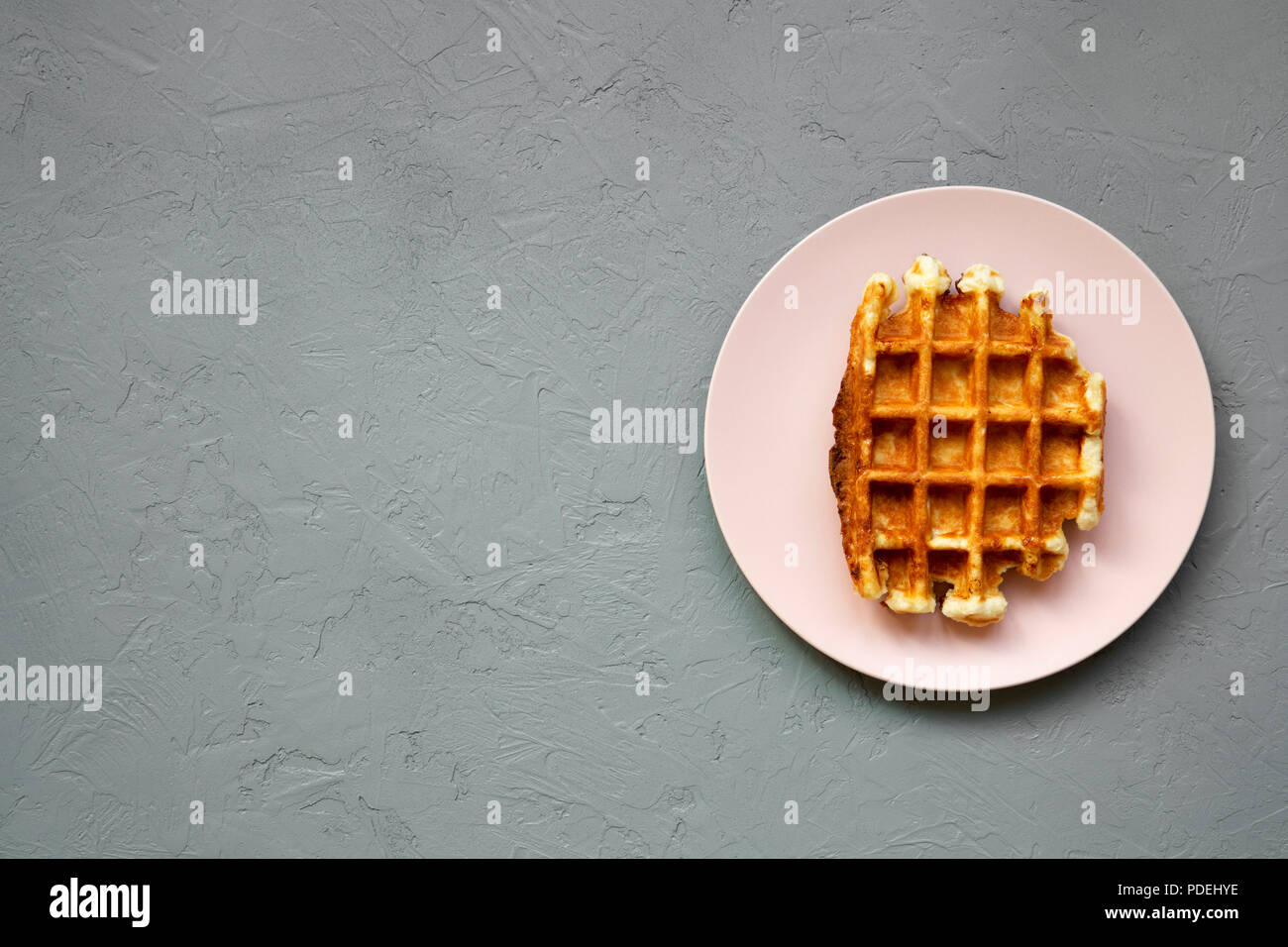 Traditional belgian waffle on pink plate over concrete surface, top ...
