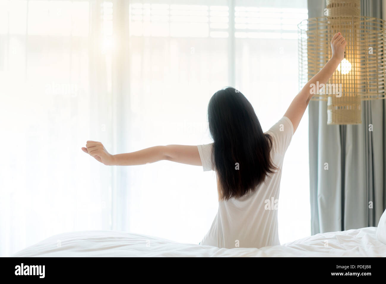 Asian Woman stretching in bed after wake up in bedroom at home, back ...