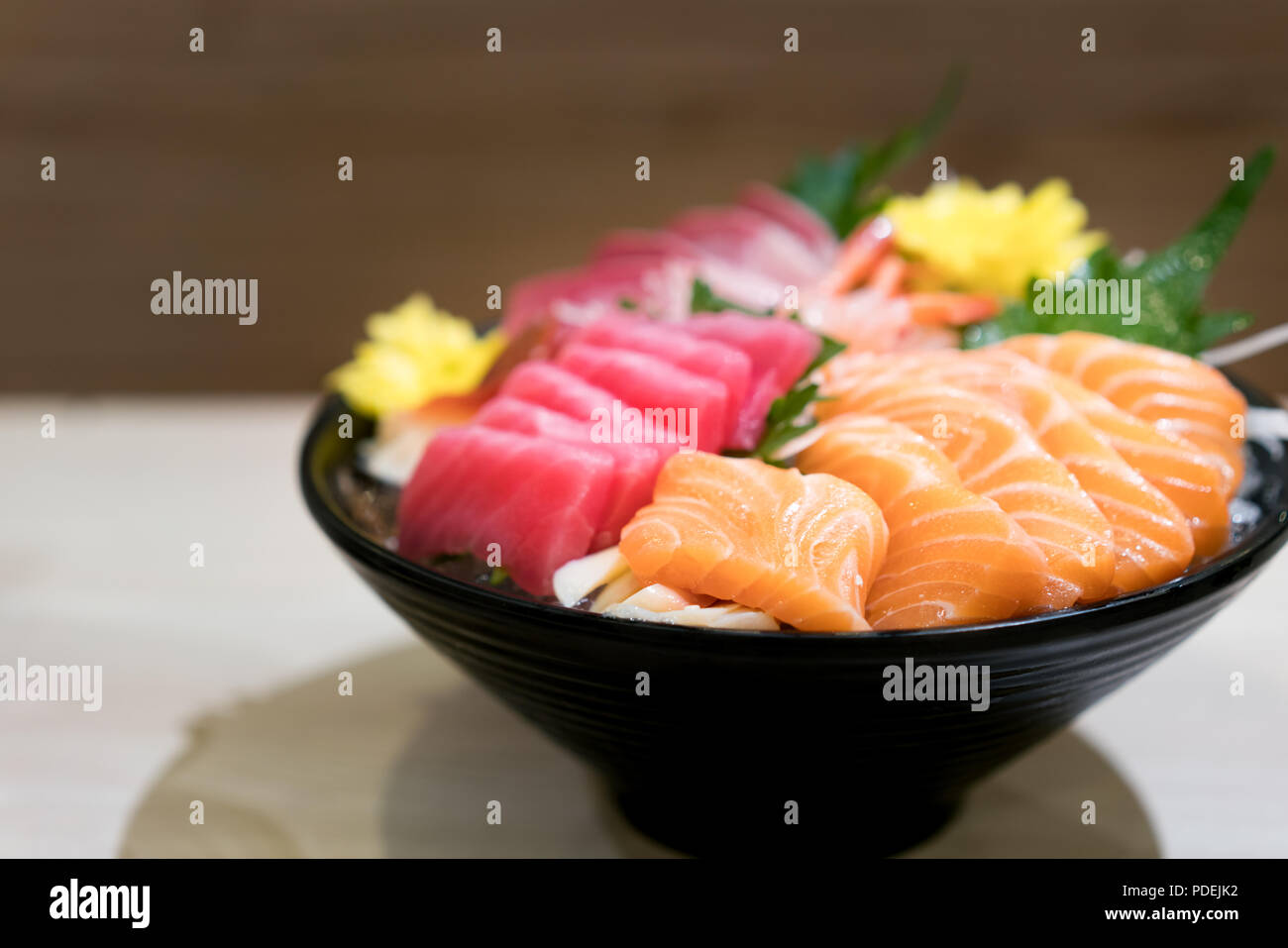 Mixed sliced fish sashimi on ice in black bowl. Sashimi Salmon Tuna ...