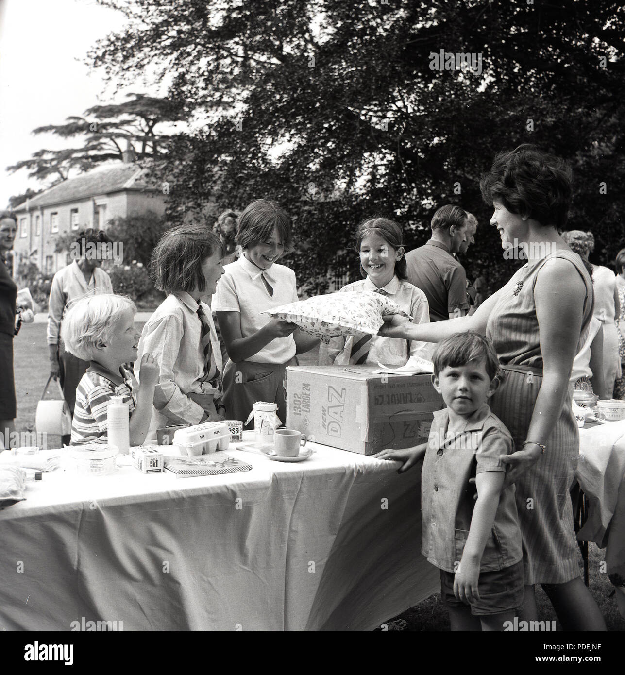 1960s, british village fete, mother gives a prize - a pillow - to the ...