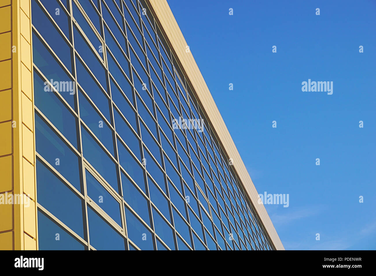 Glass surface facade with windows in a modern building. Sky reflecting ...