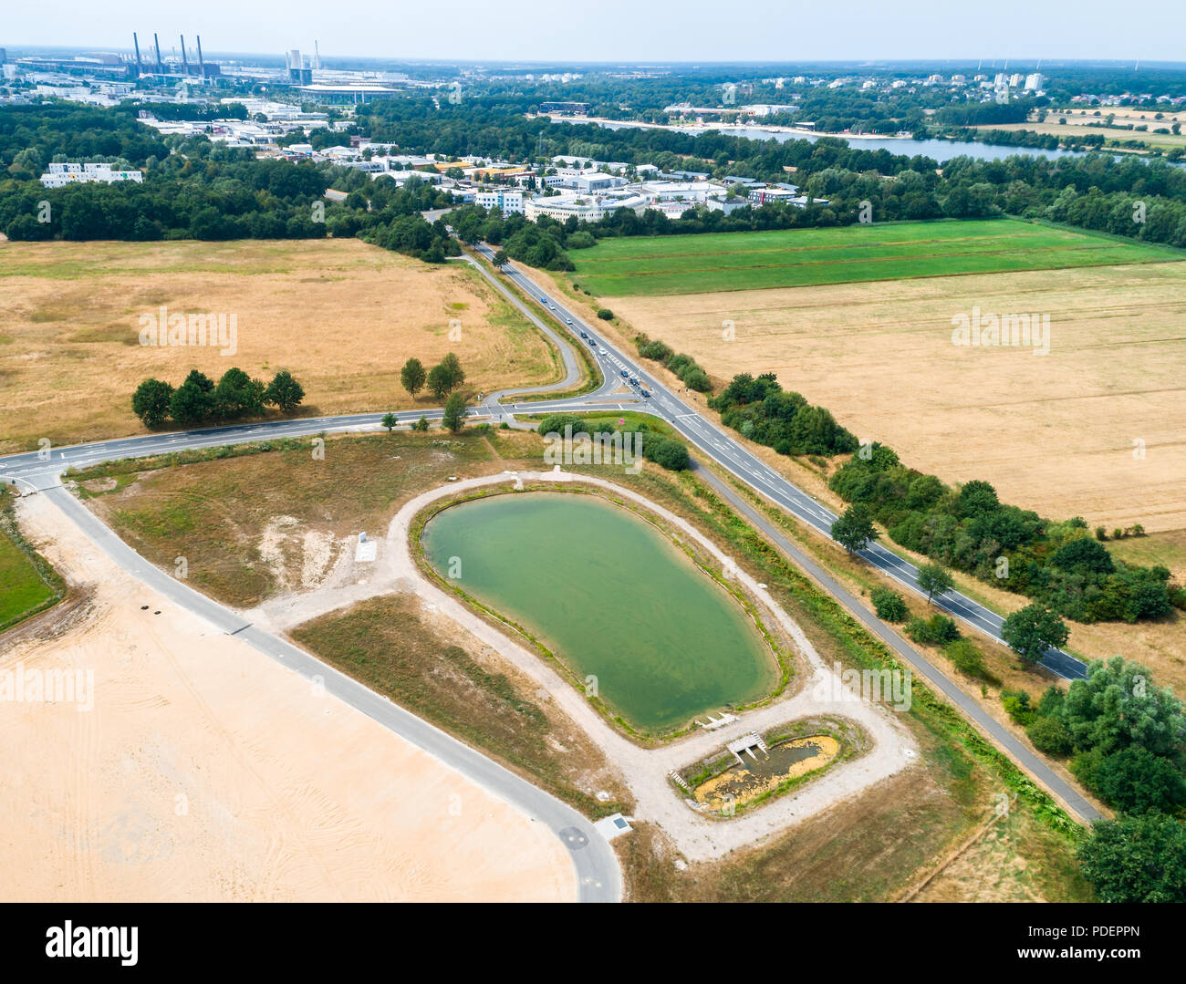 Aerial view of a rain retention basin at the edge of a new development ...