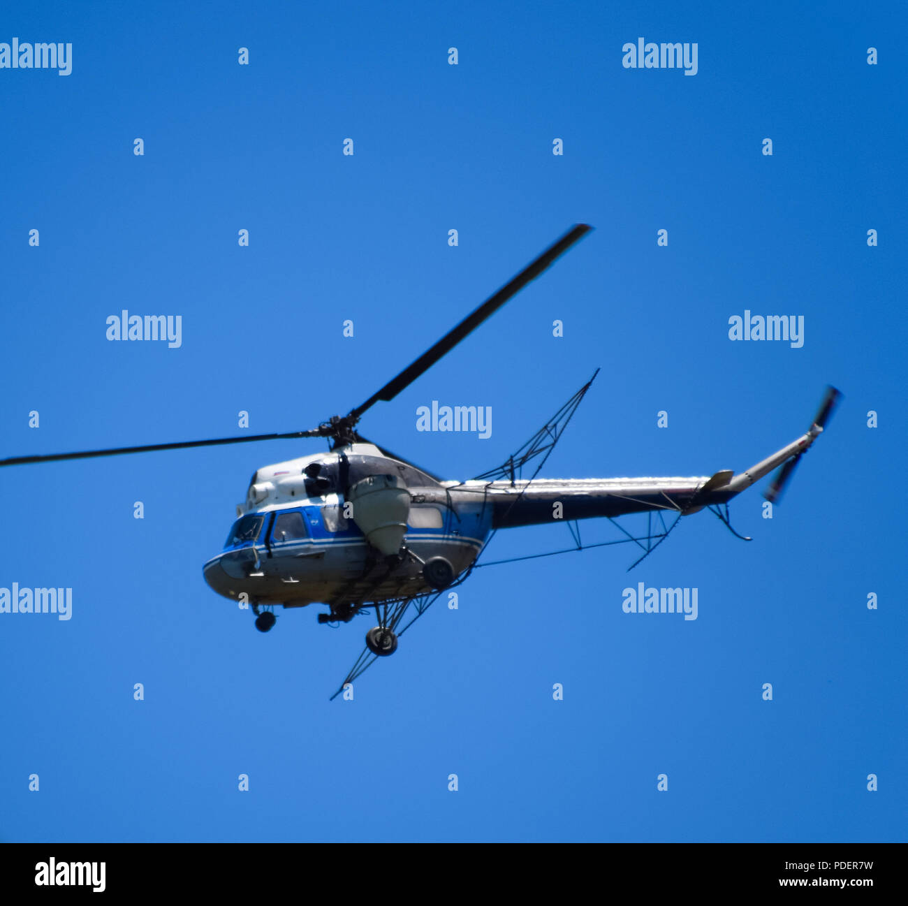 A helicopter of agricultural aviation is flying in the blue sky Stock ...