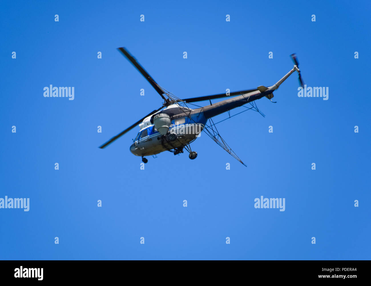 A helicopter of agricultural aviation is flying in the blue sky Stock ...