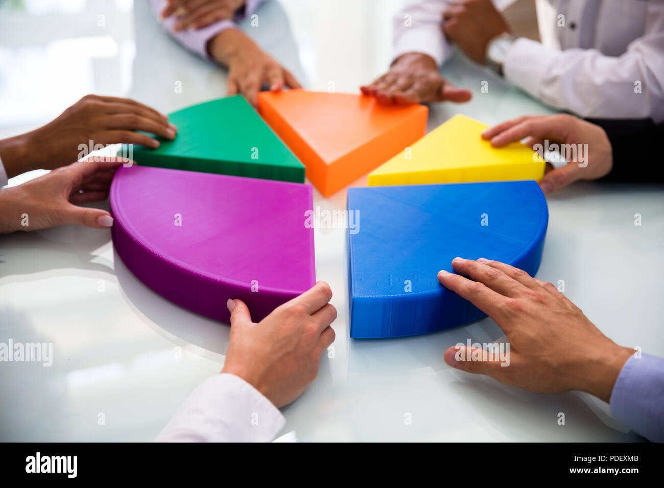 Businesspeople Hand Connecting Multi Colored Pieces Of Pie Chart On ...