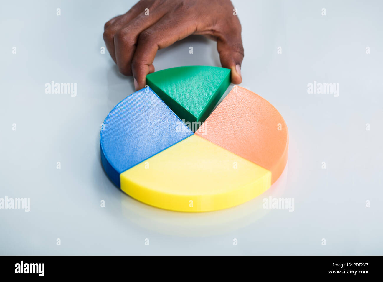 Overhead View Of Human Hand Taking Green Piece Of Pie Chart On Gray ...