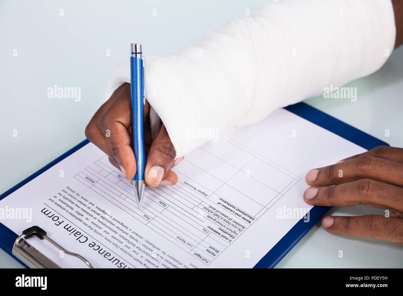 Overhead View Of Injured Man With Bandage Hand Filling Insurance Claim ...