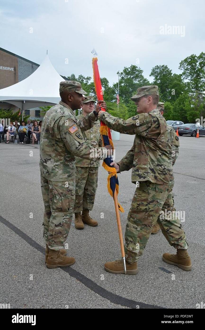 Col. John Joseph, incoming 1st Brigade commander (right) passes the unit guidon to Command Sgt ...