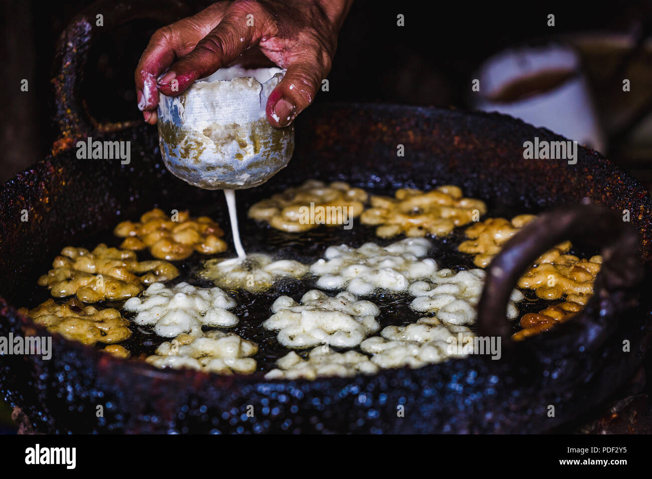A hand making indian nepali sweet dish Jilebi or jeri in the street of ...