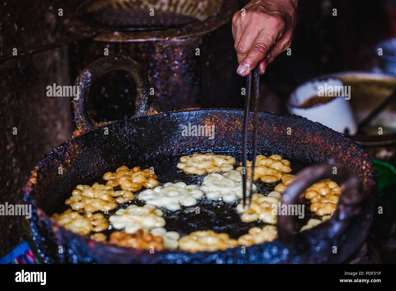 A hand making indian nepali sweet dish Jilebi or jeri in the street of ...
