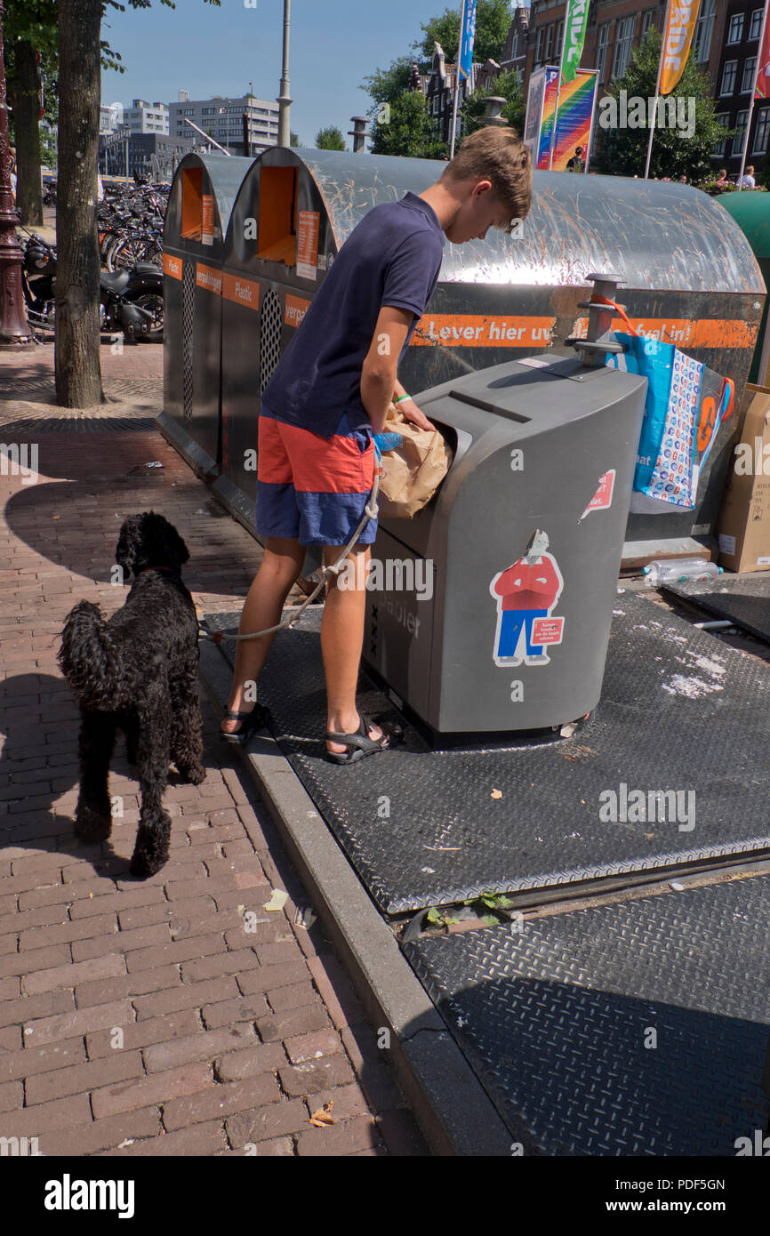 Young man local resident recycling waste in designated containers in ...