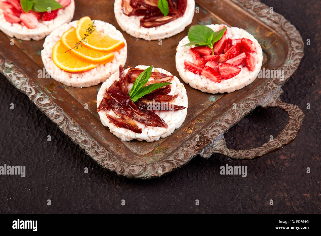 Snack with rice crispbread and fresh fruits on metal tray brown ...