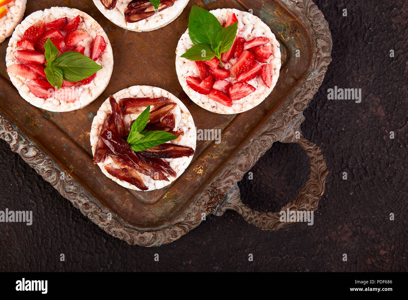 Snack with rice crispbread and fresh fruits on metal tray brown ...