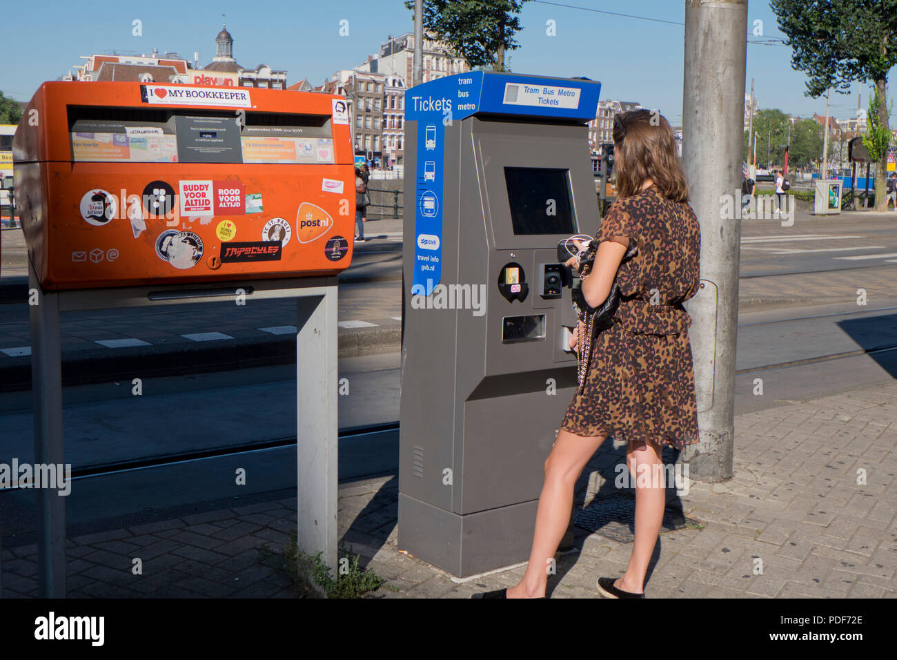 Woman buying tram ticket from automatic machine on a street in ...