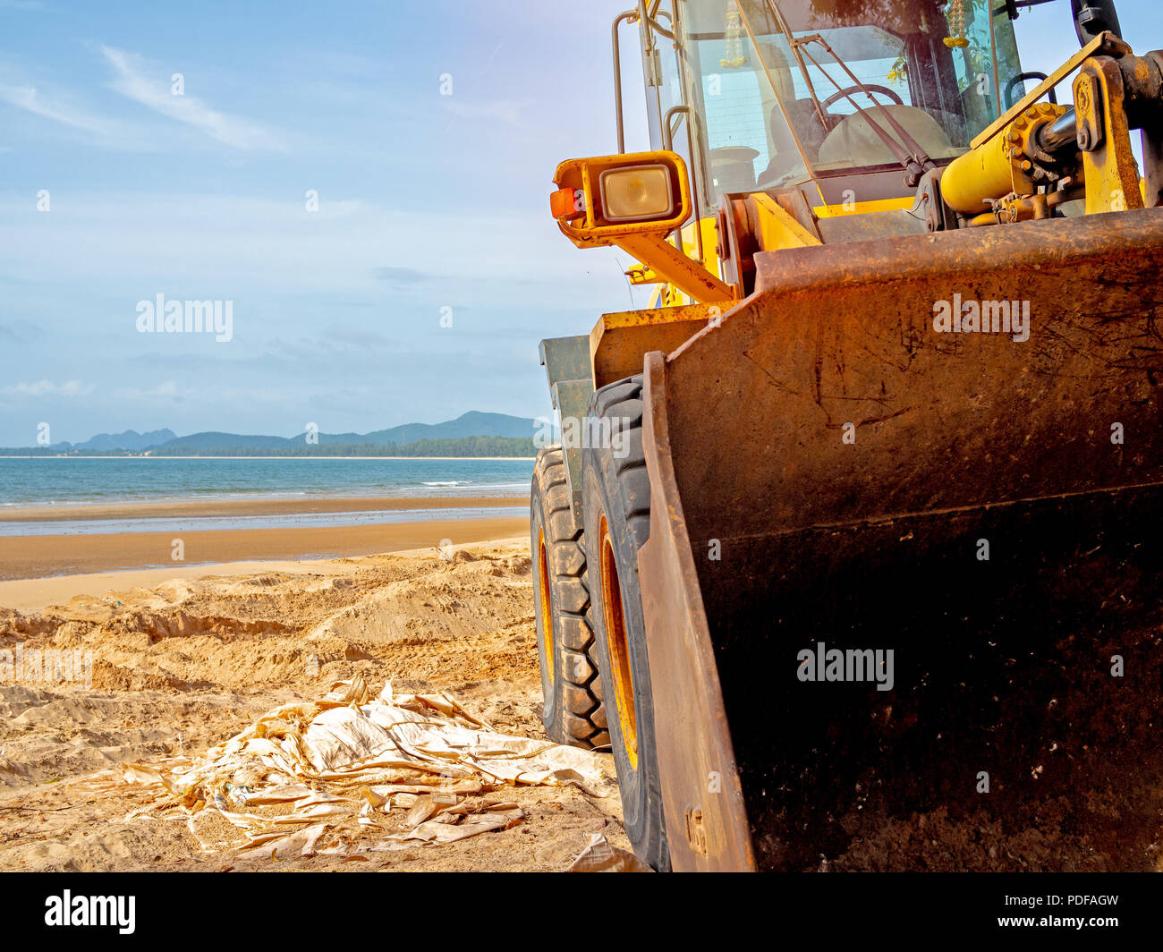 Yellow Excavator working on the beach with sea view on seascape and ...