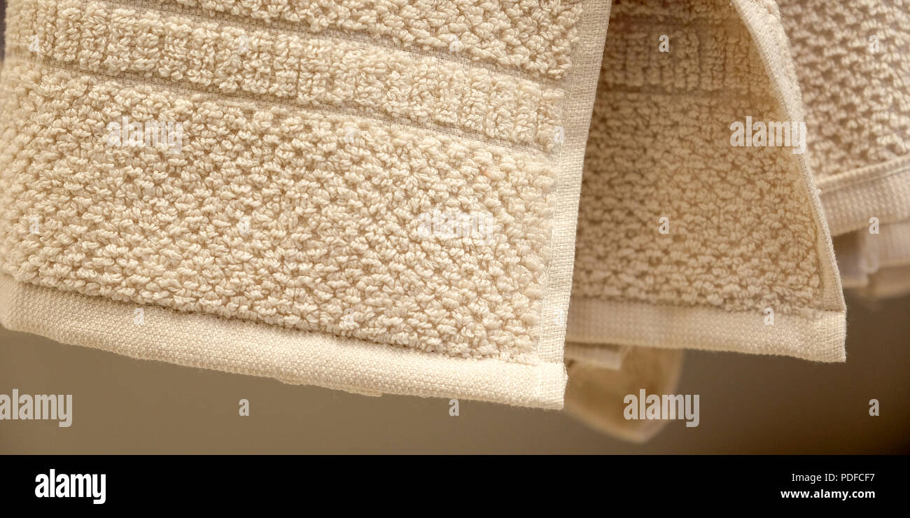 Clean colored towels hanging on the hanger in the bathroom. Towels are ...