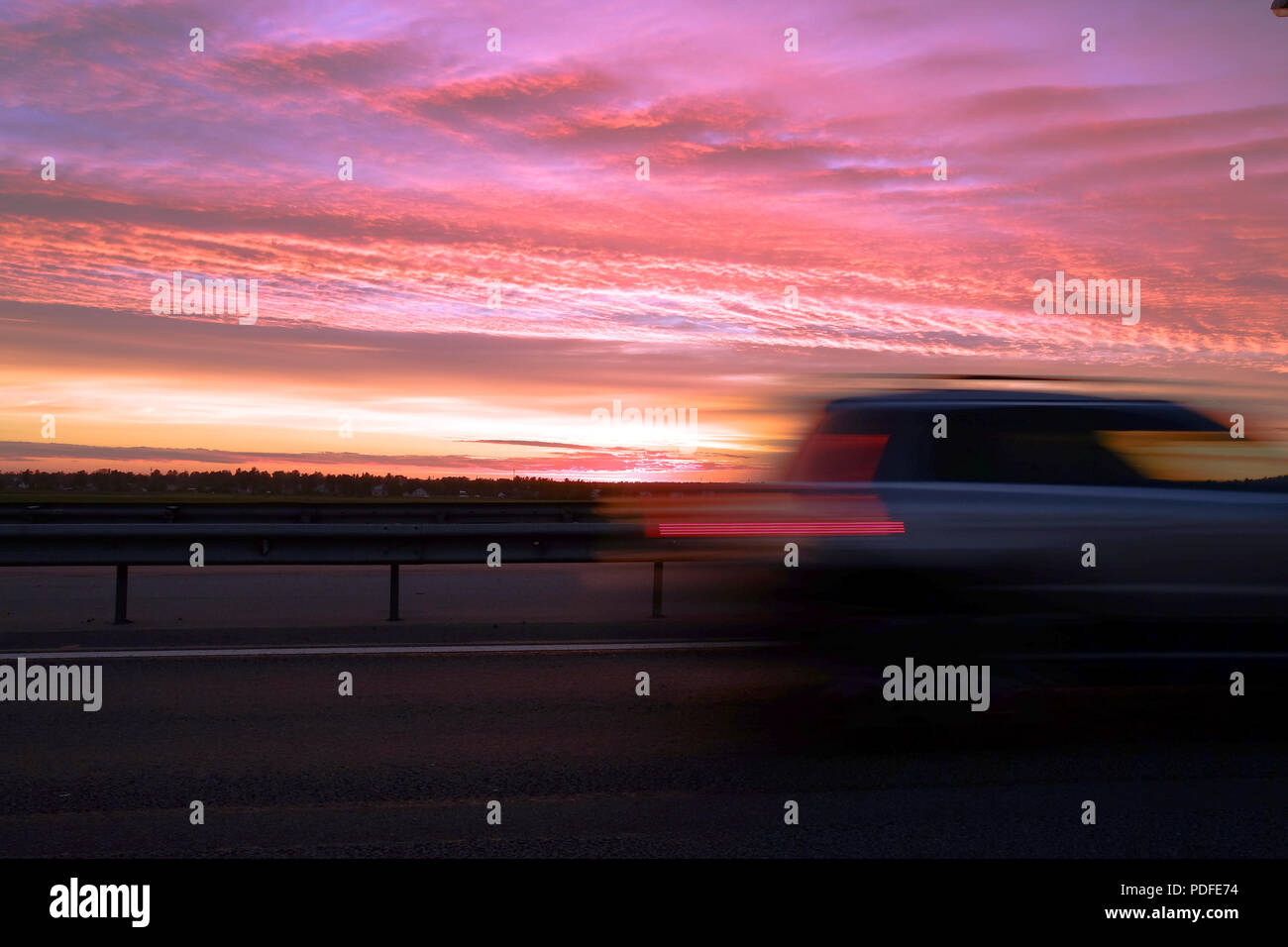 Interchange of the highway. Dramatic sky, fiery sunset. The lights on ...