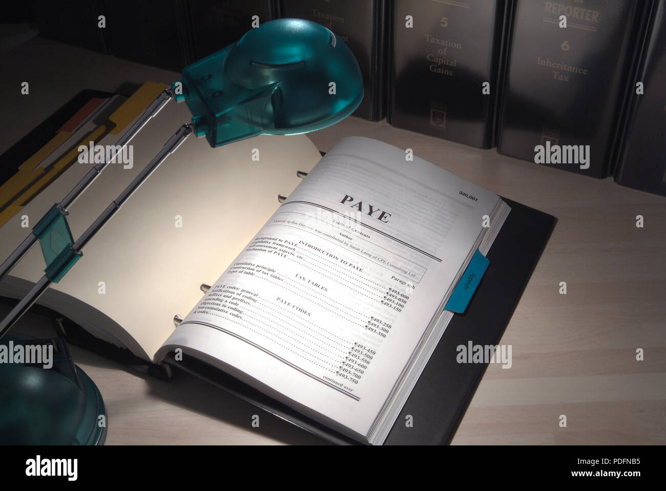 PAYE advice manual under desk lamp Stock Photo - Alamy