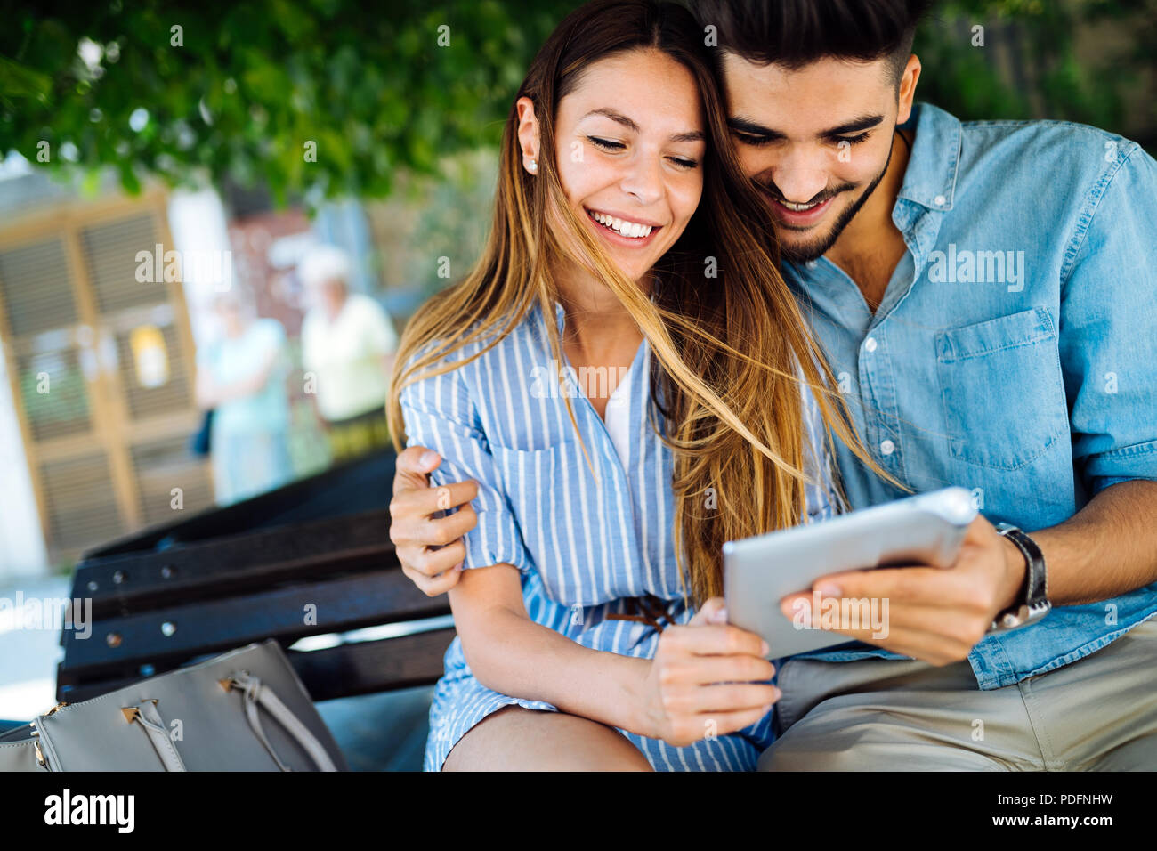 Young attractive couple on date sitting on bench Stock Photo - Alamy