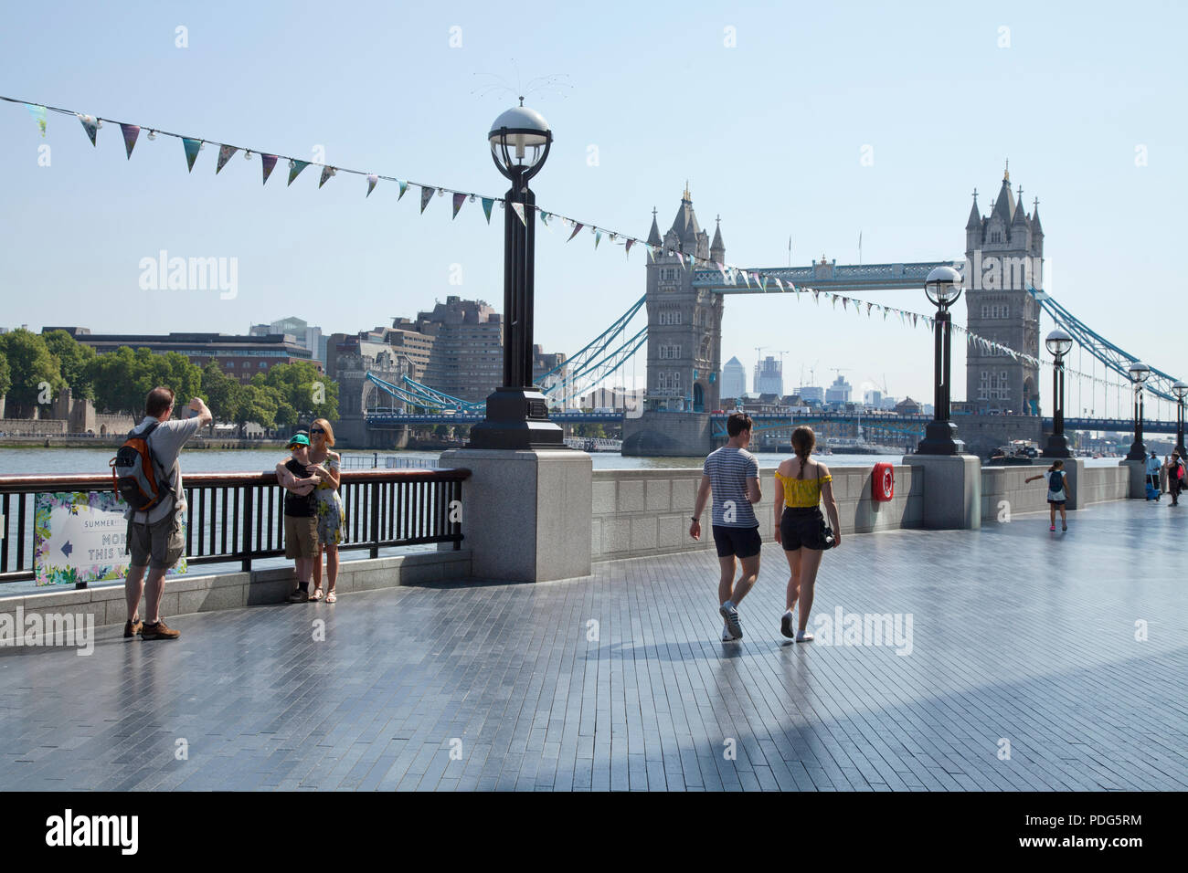 Summer morning on London's Southbank with Tower Bridge and father ...