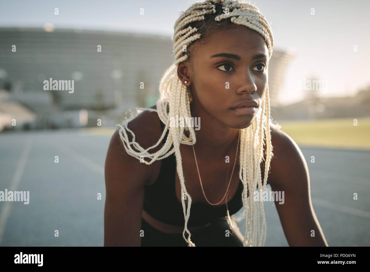 Close up of a female runner ready on her marks on a running track ...