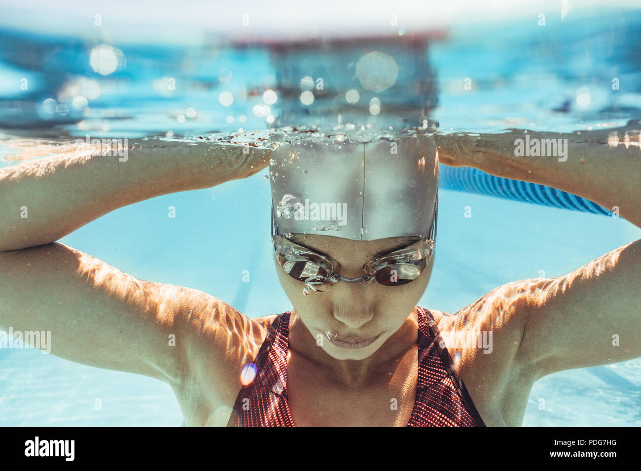 Underwater shot of woman inside swimming pool. Female swimmer in swim ...