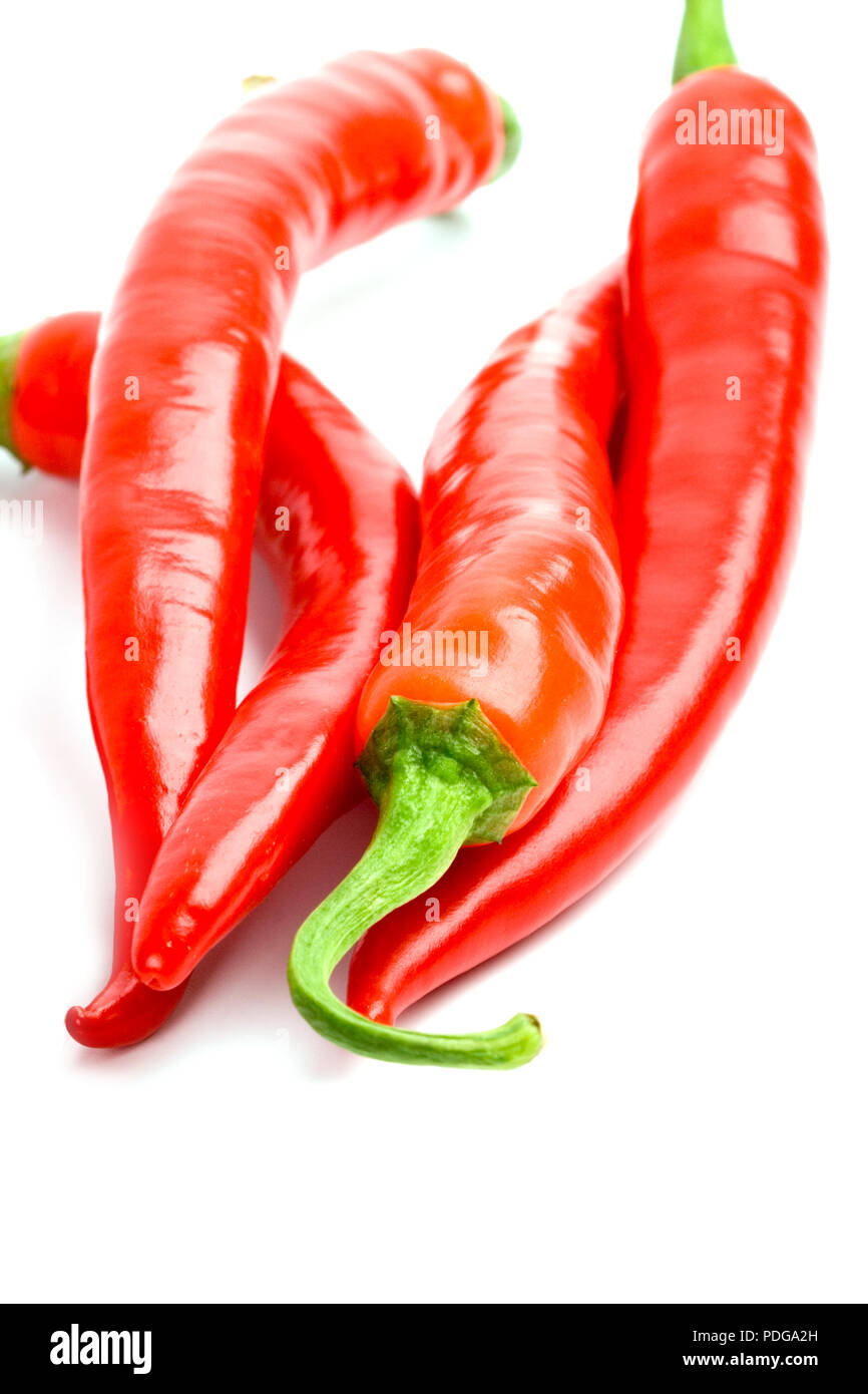 four red chilly peppers closeup on white background Stock Photo - Alamy