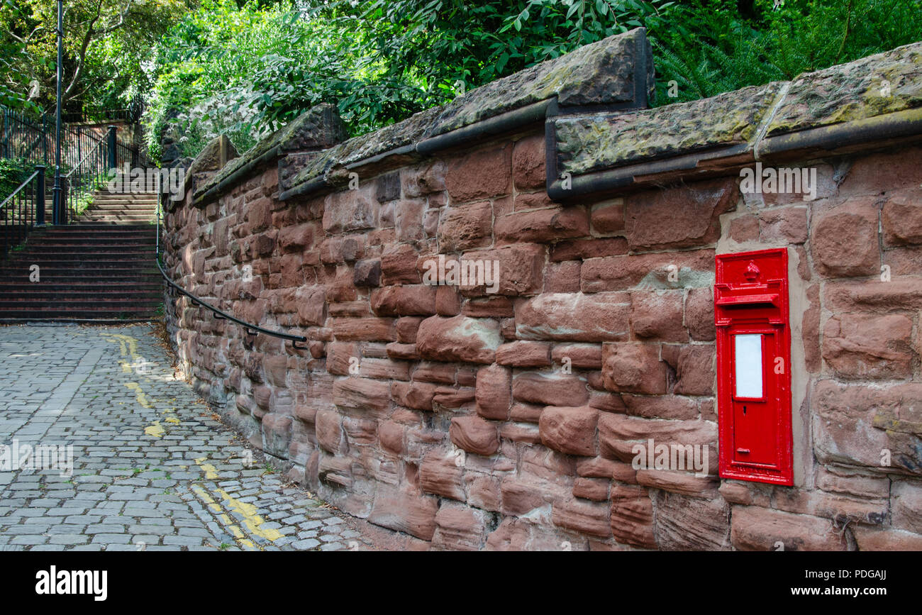 A traditional British postbox mounted in a red stone wall. With copy ...