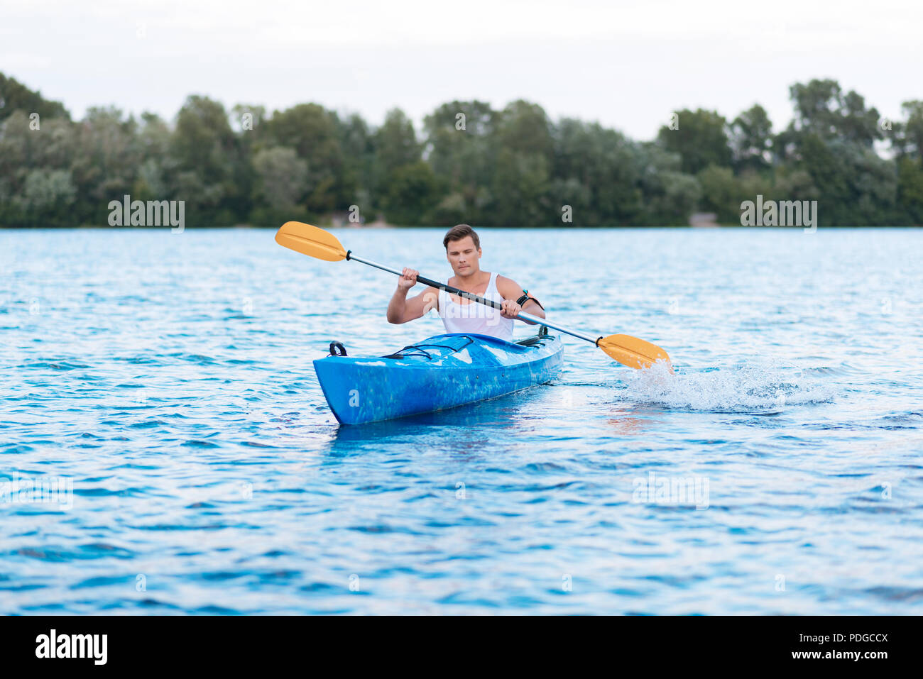 Strong muscle man holding paddles while rowing in canoe Stock Photo - Alamy