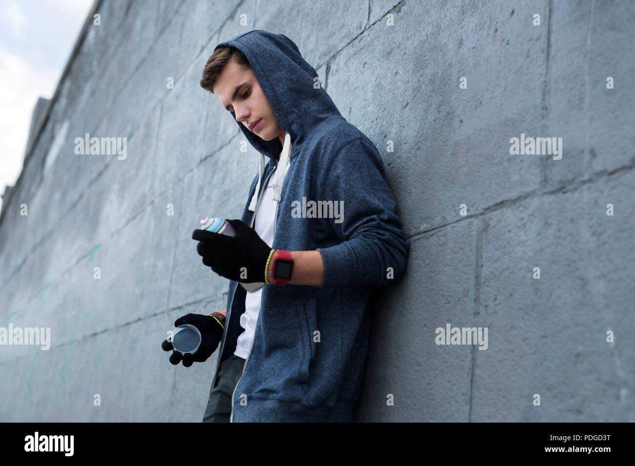 Serious young man looking at the spray paint Stock Photo - Alamy