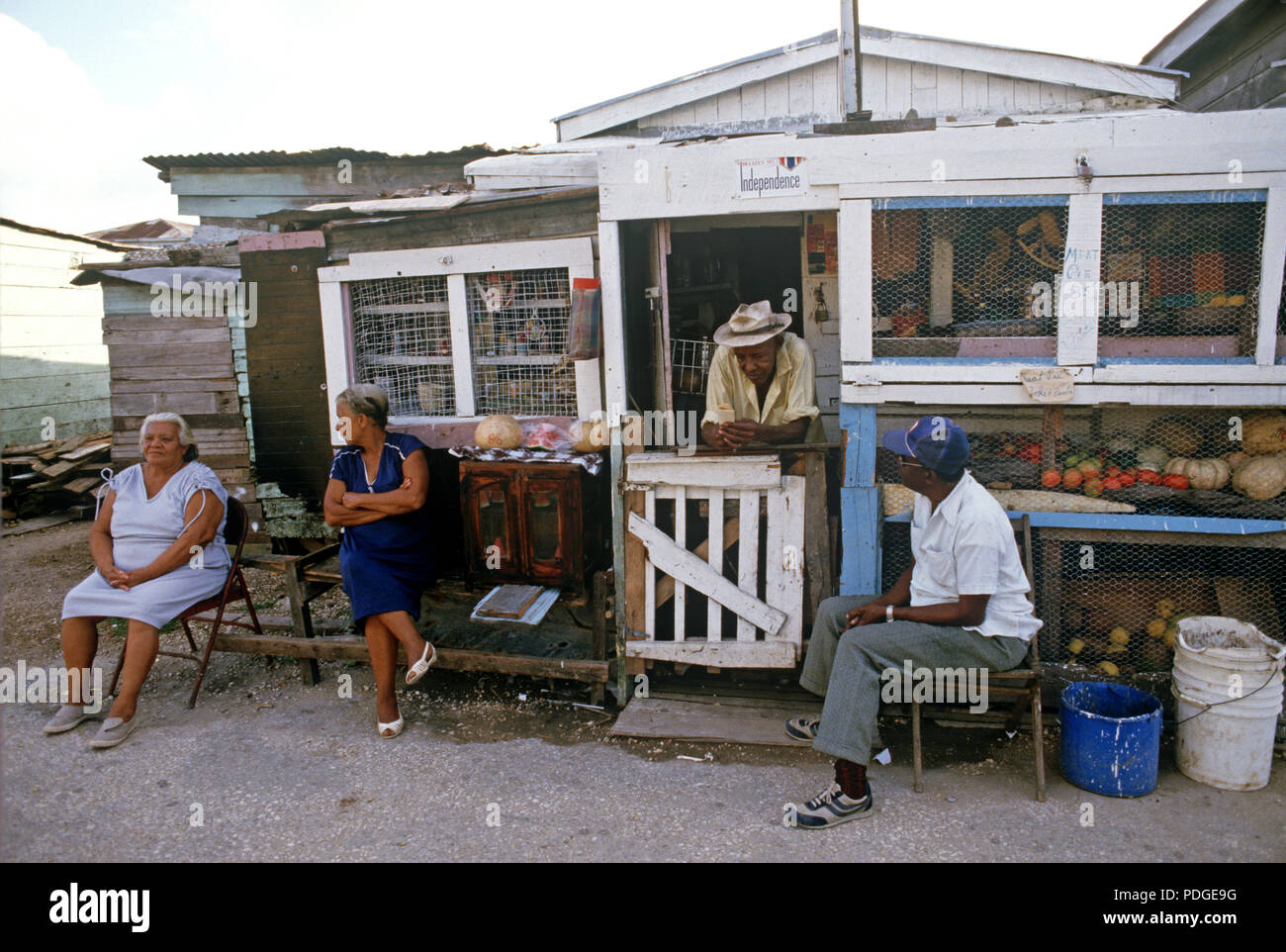 Belizeans sitting in front of wooden clad shop in Belize City, Belize ...