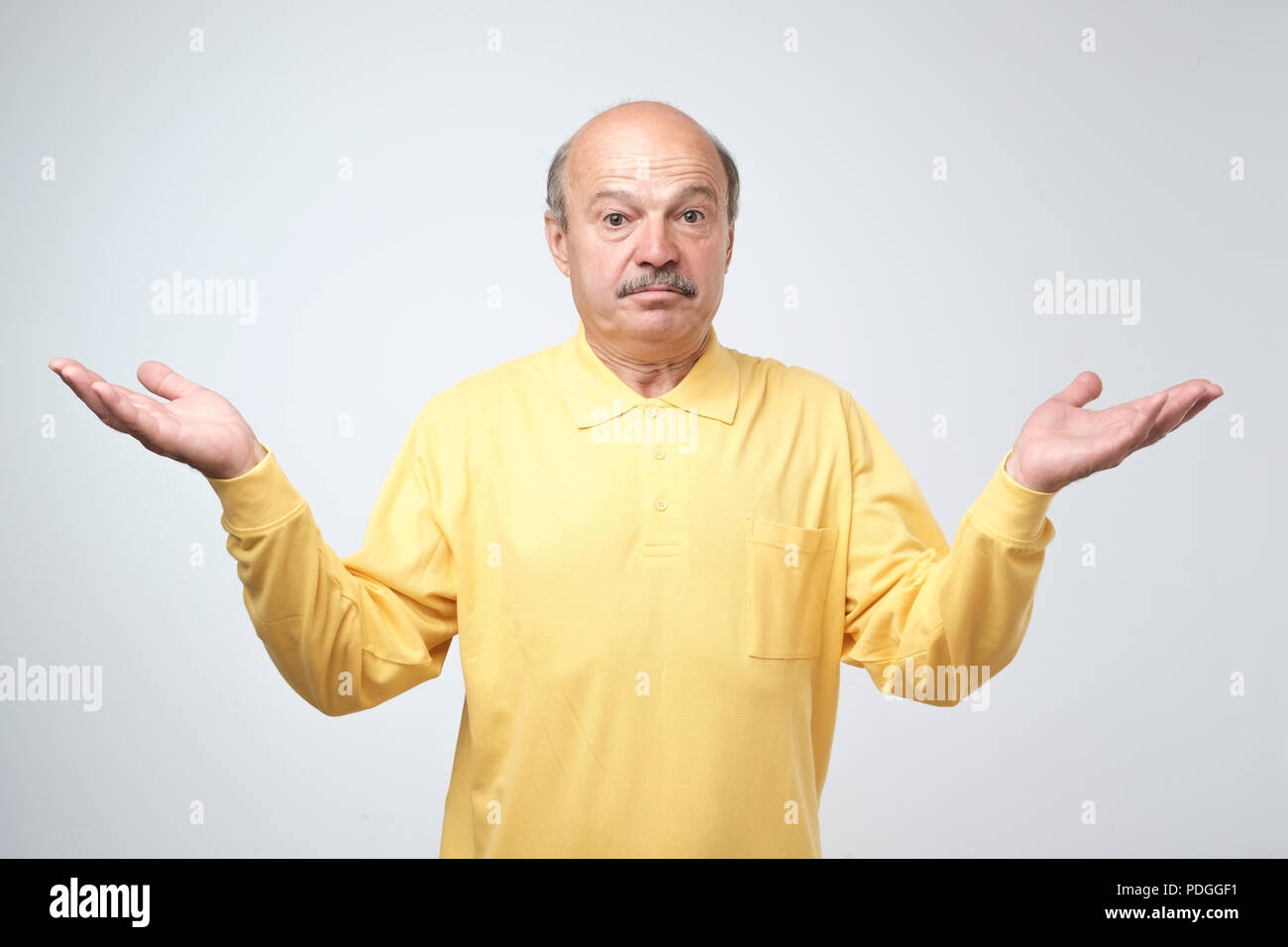 Emotional senior man not sure for something. Studio shot, gray ...