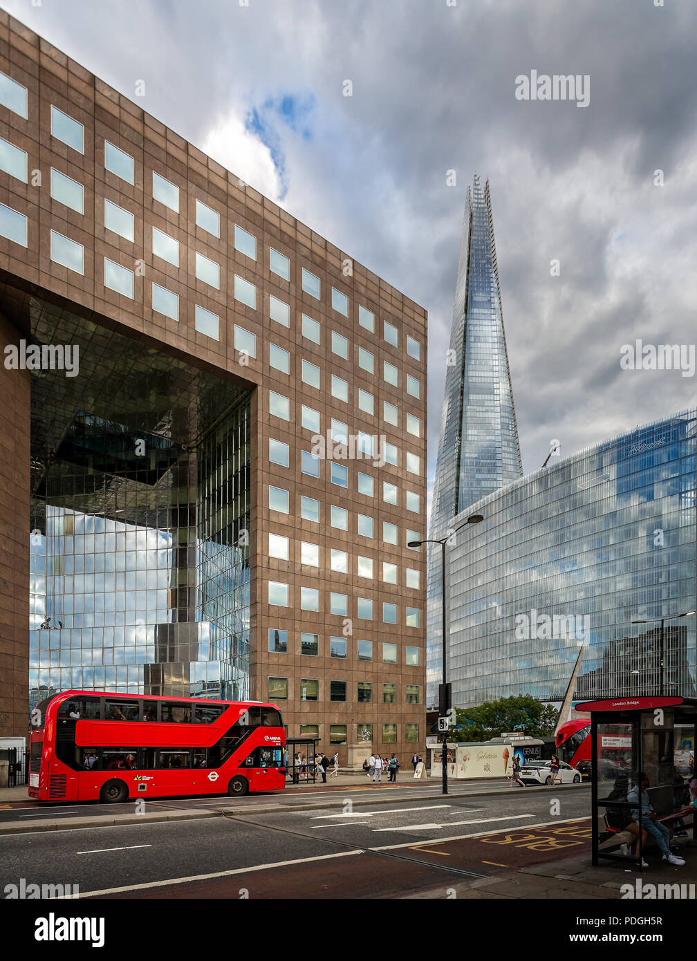 Red London bus driving in front of The Shard in London, UK on 8 July ...