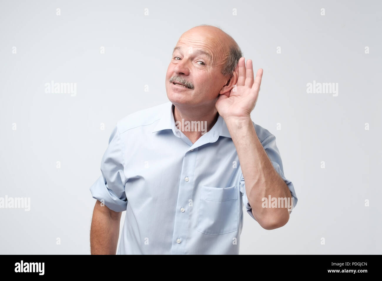 Portrait of senior casual man which overhears conversation over white ...