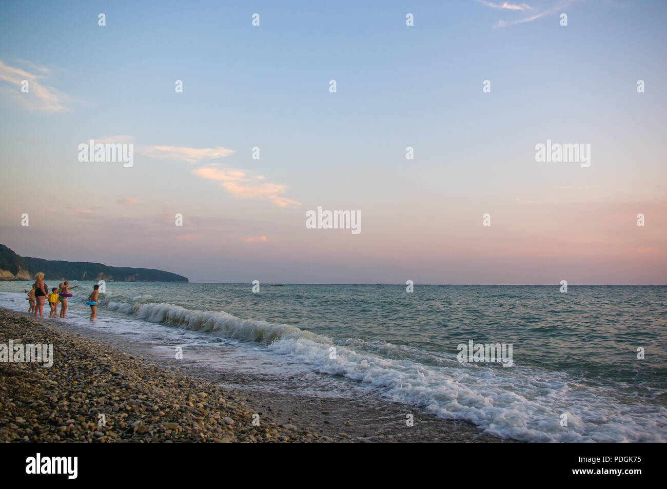 Summer sea sunset on the pebble beach, the sun, waves and clouds ...