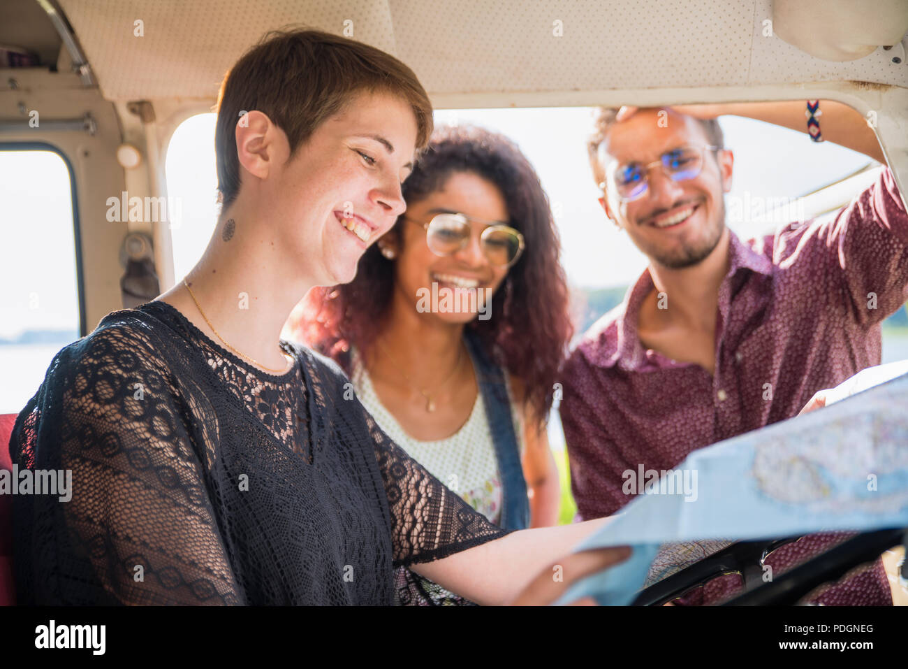 Mixed group of happy young people in a car looking at a map Stock Photo ...