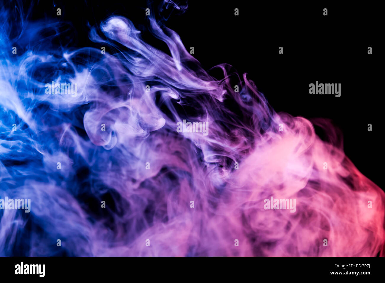 Dense purple, pink and blue smoke on a black isolated background ...