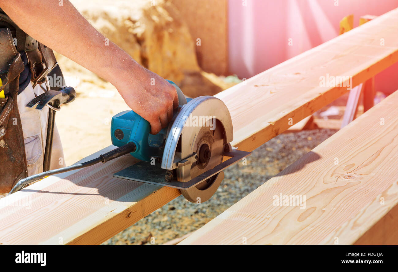 workers using chain saw cutting and sawing industrial construction wood ...