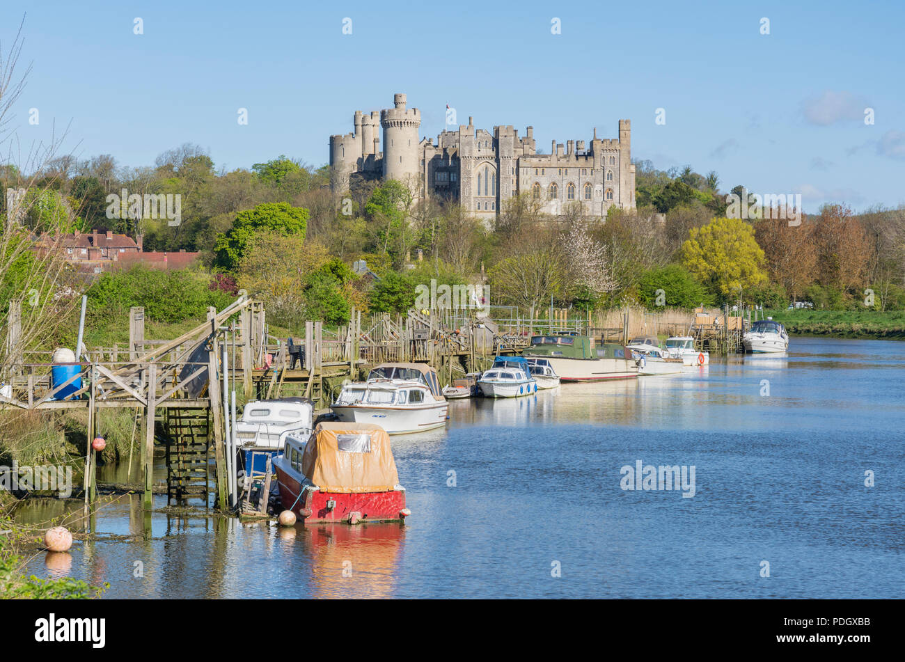 River Arun with boats moored up and Arundel Castle in the distance, in ...