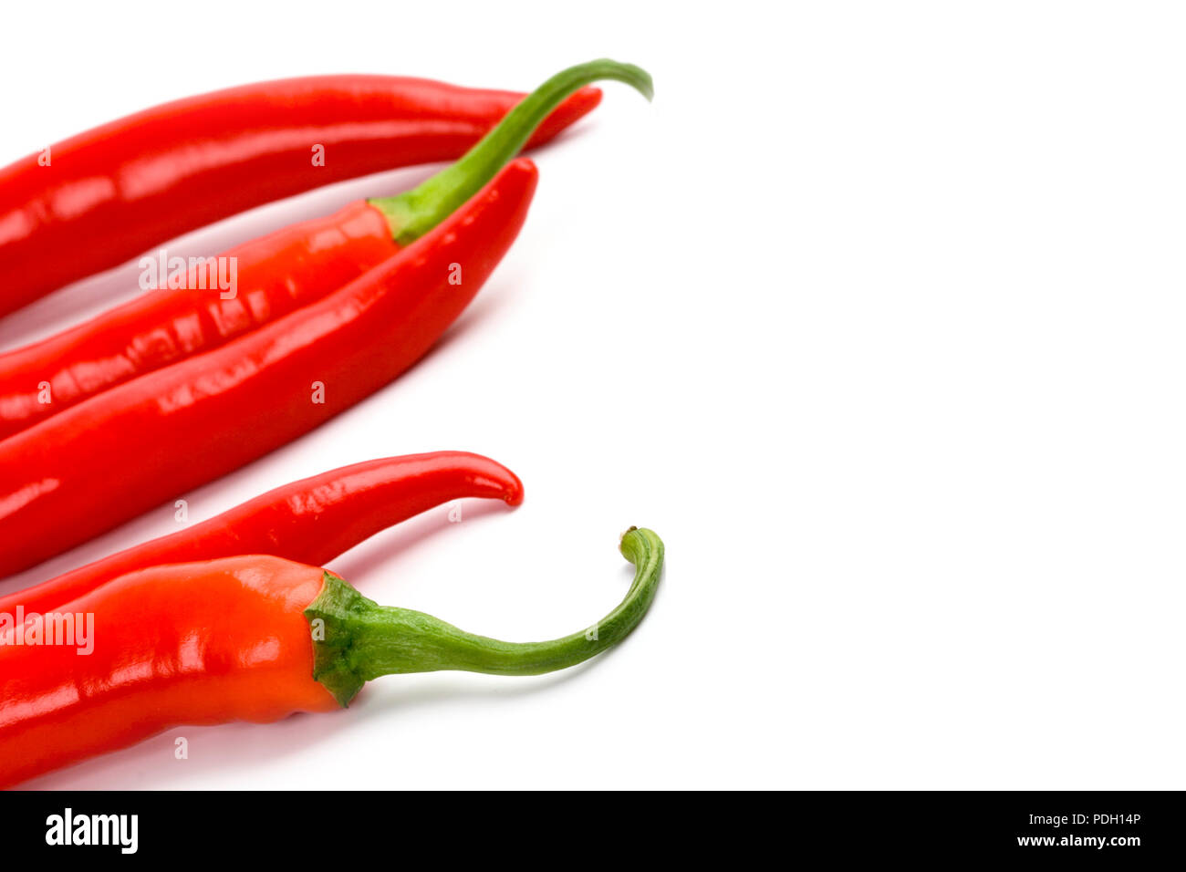five red chilly peppers closeup on white background Stock Photo - Alamy