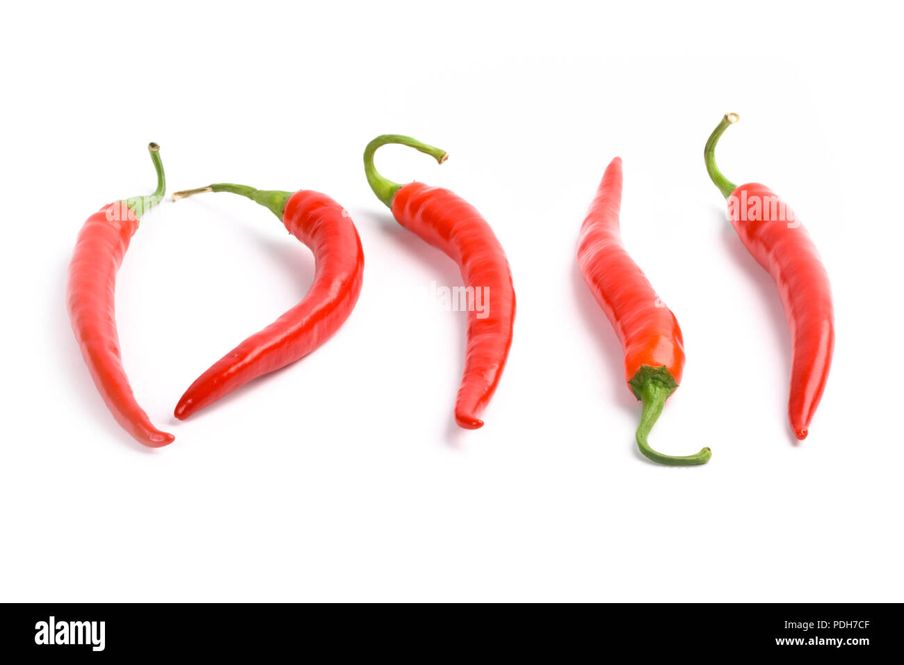 five red chilly peppers isolated on white background Stock Photo - Alamy