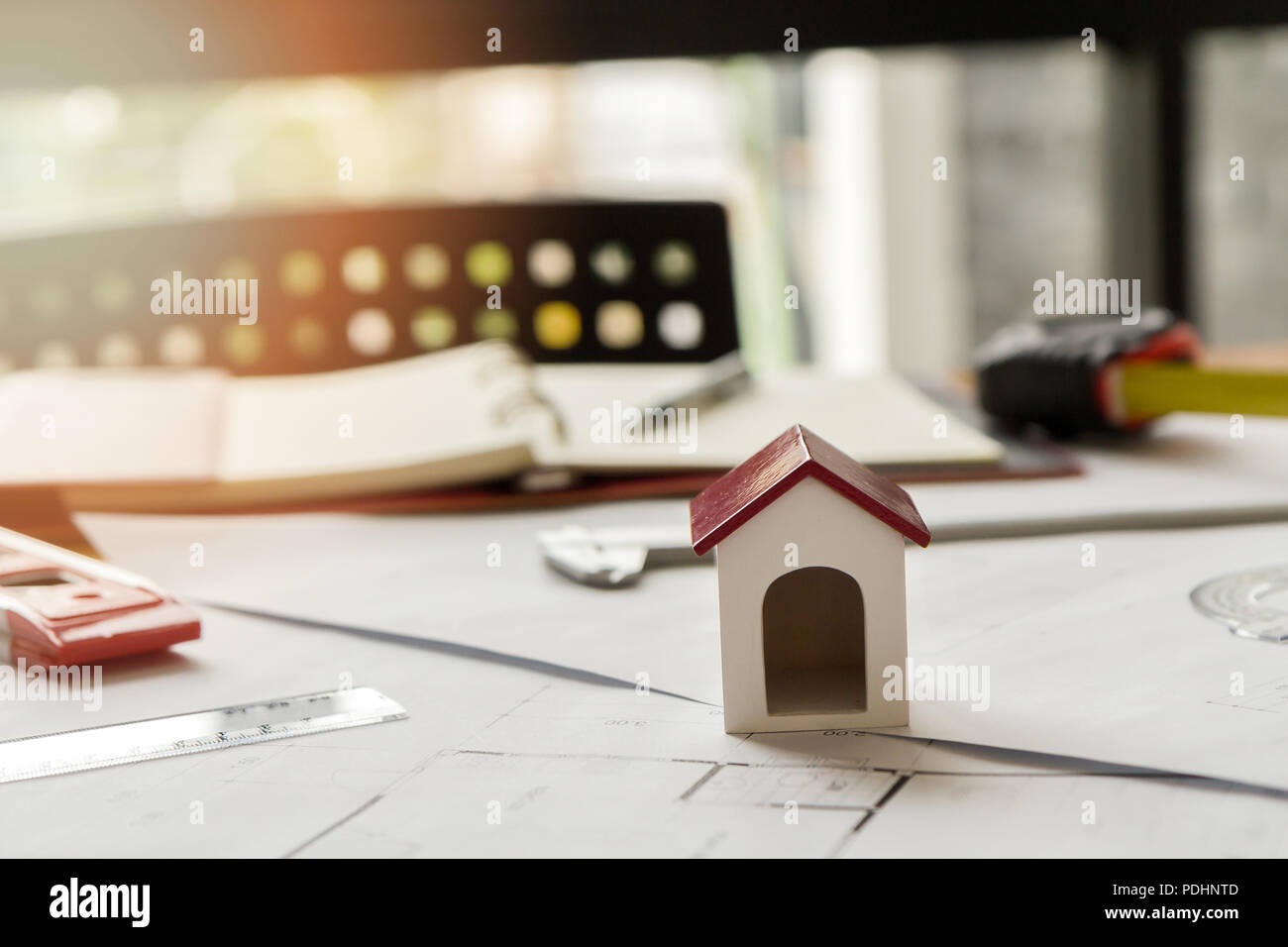 A architects house model with plan and blueprints on architect desk ...