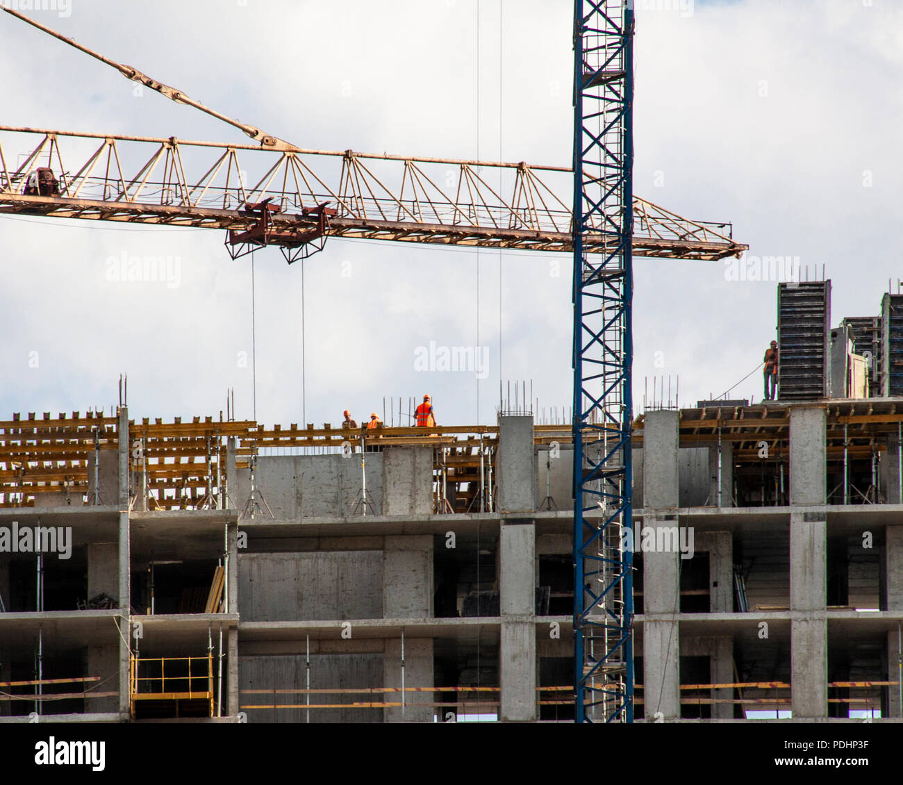 Crane and building under construction against blue sky Stock Photo - Alamy