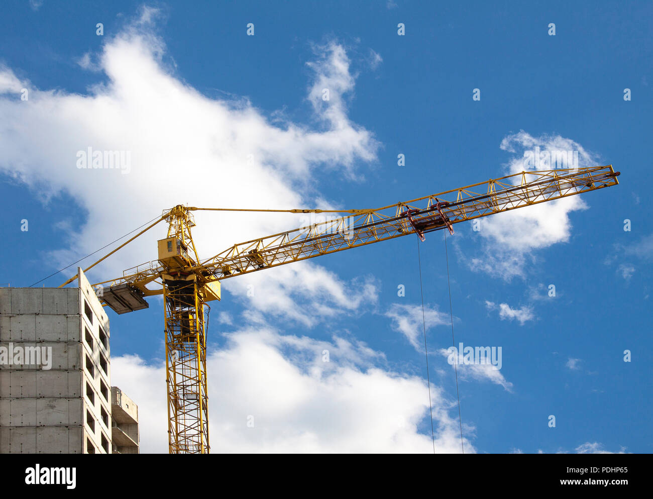 Crane and building under construction against blue sky Stock Photo - Alamy