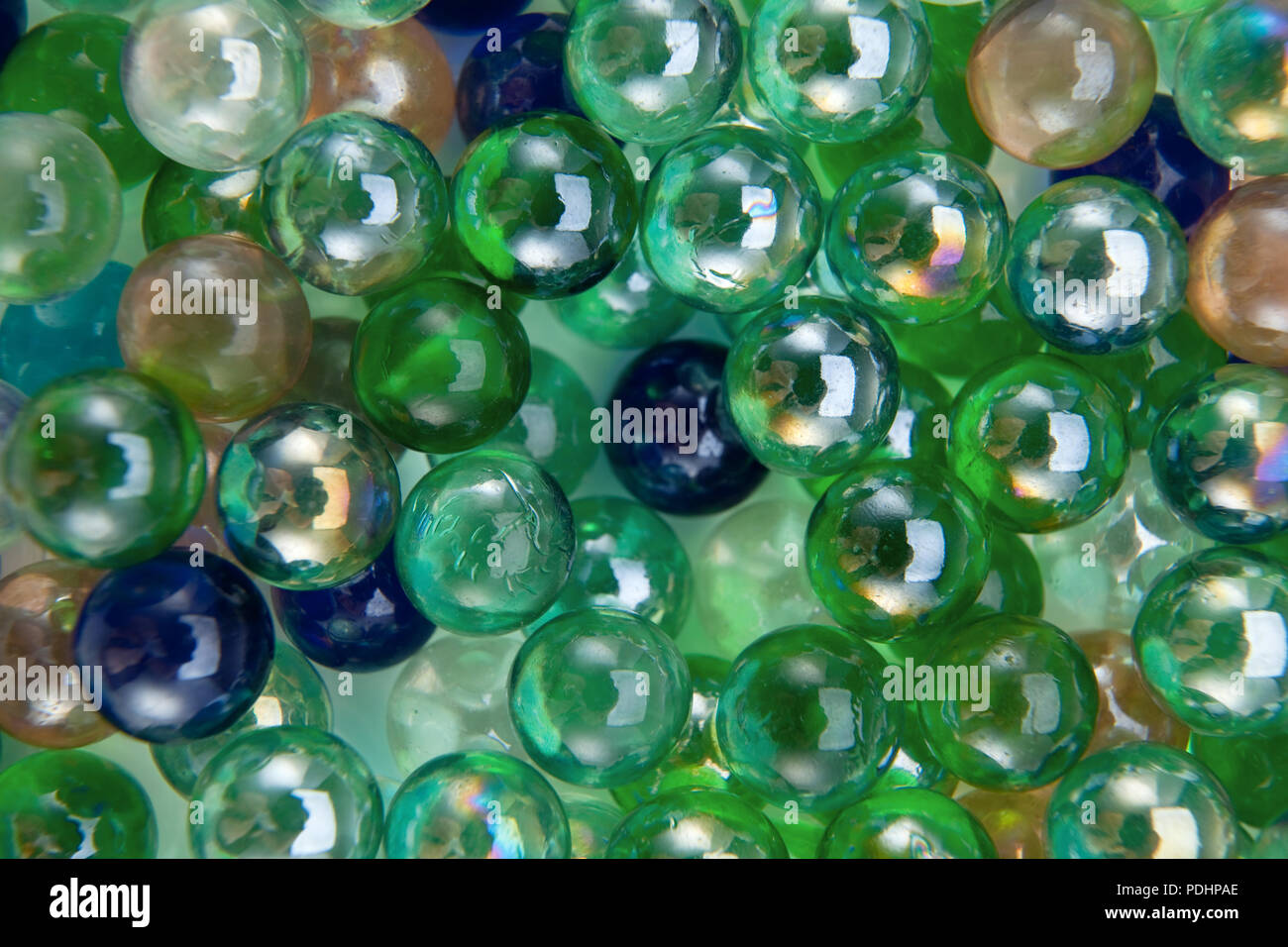 group of marbles in a variety of colors isolated on a white background ...