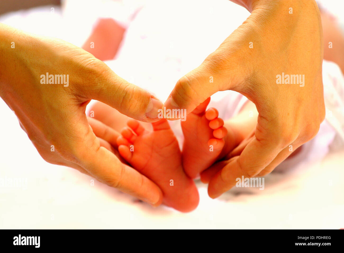 heart shape with the new born legs Stock Photo - Alamy
