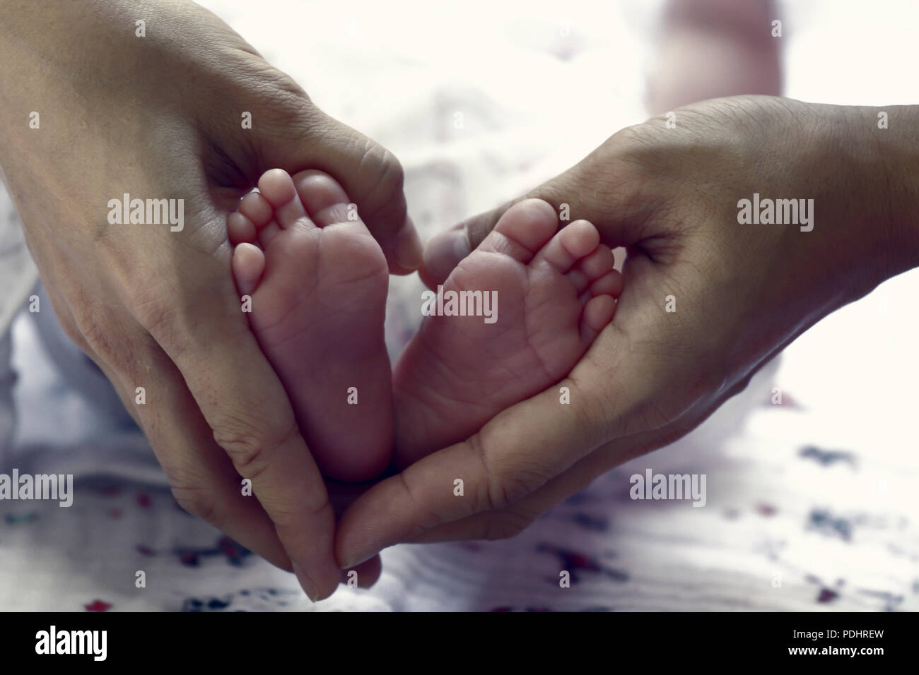 heart shape with the new born legs Stock Photo - Alamy