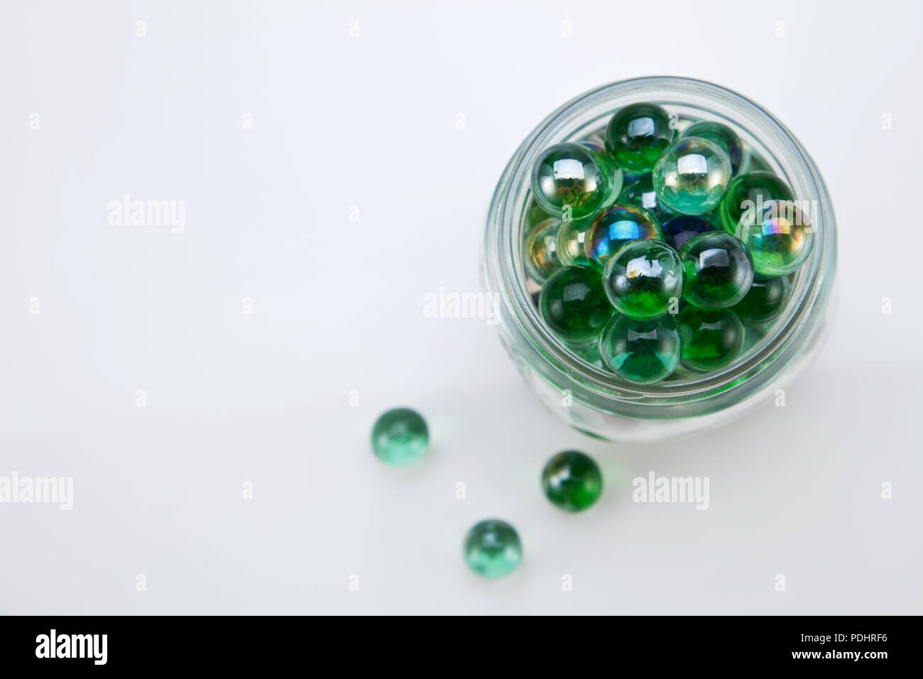 group of marbles in a variety of colors isolated on a white background ...
