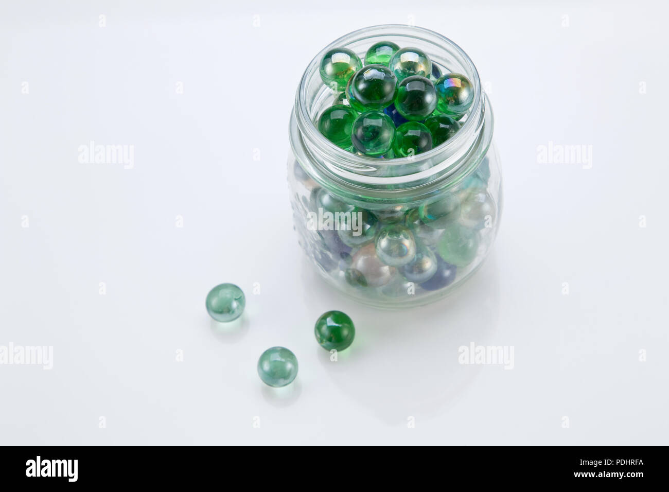group of marbles in a variety of colors isolated on a white background ...